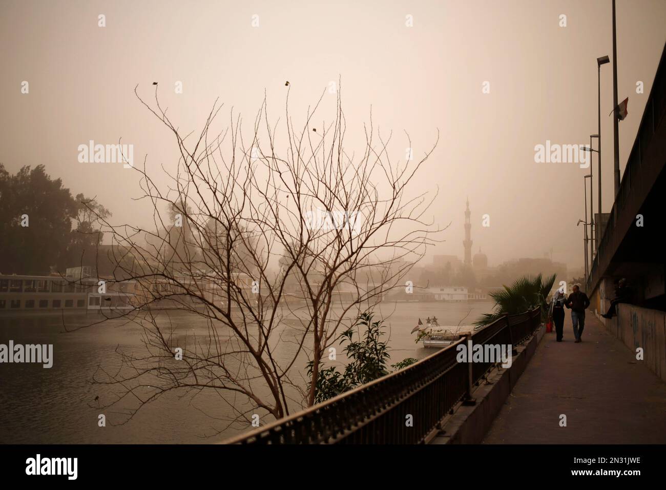 An Egyptian couple walk together under a bridge during a sandstorm in ...