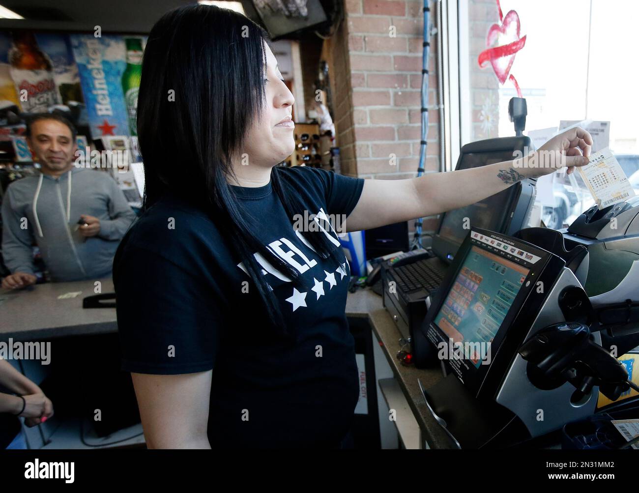 Cashier Miriam Garibay pulls a Powerball ticket from the dispenser for ...