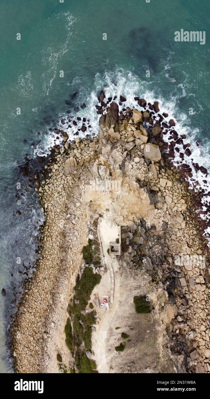 A vertical drone shot of the rocky edge of the continent and the sea ...