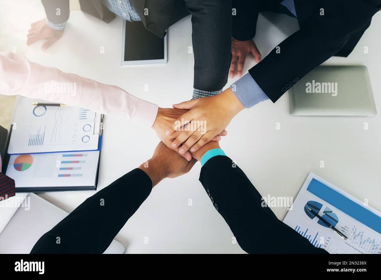 Concept of teamwork: Top view of hands of business team showing unity with putting their hands ...