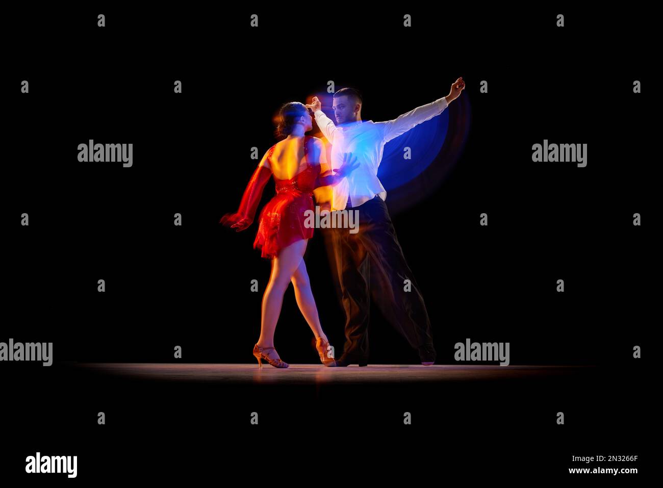 Expressive artistic young man and woman dancing tango, ballroom over black background with mixed ...
