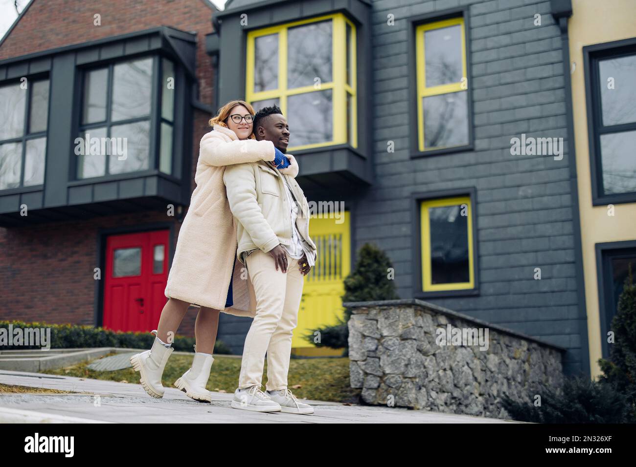Young interracial couple embraces on street against background of ...
