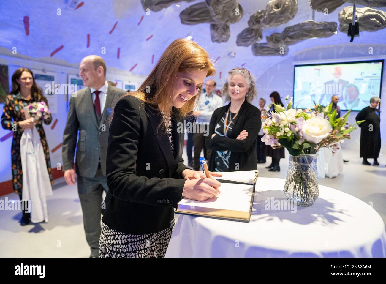 Princess Beatrice signs the visitors book during a visit to the the ...
