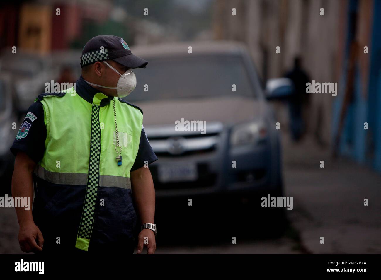 A traffic police officer covers his face with a mask as he works on a ...