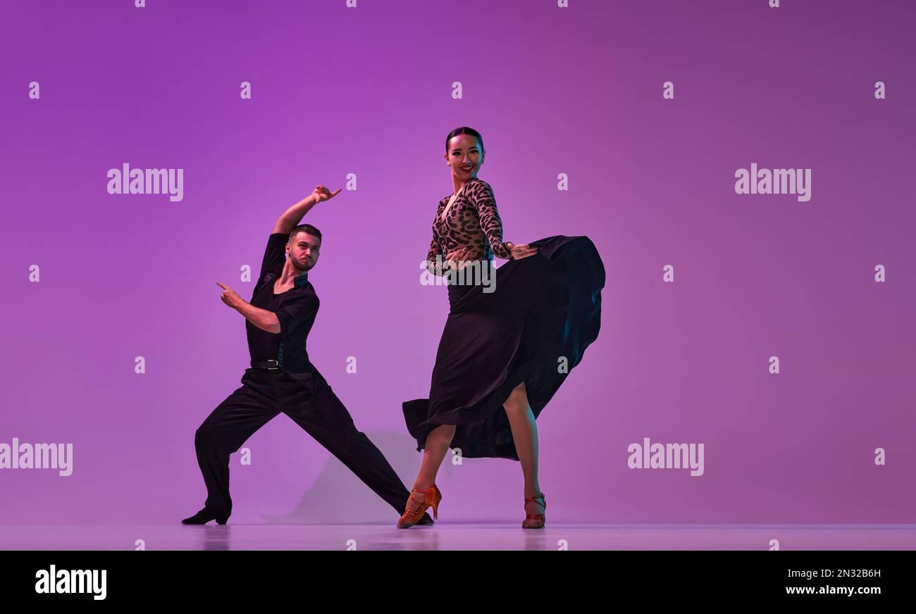 Man and woman, professional dancers in stylish, beautiful stage costumes performing tango over ...
