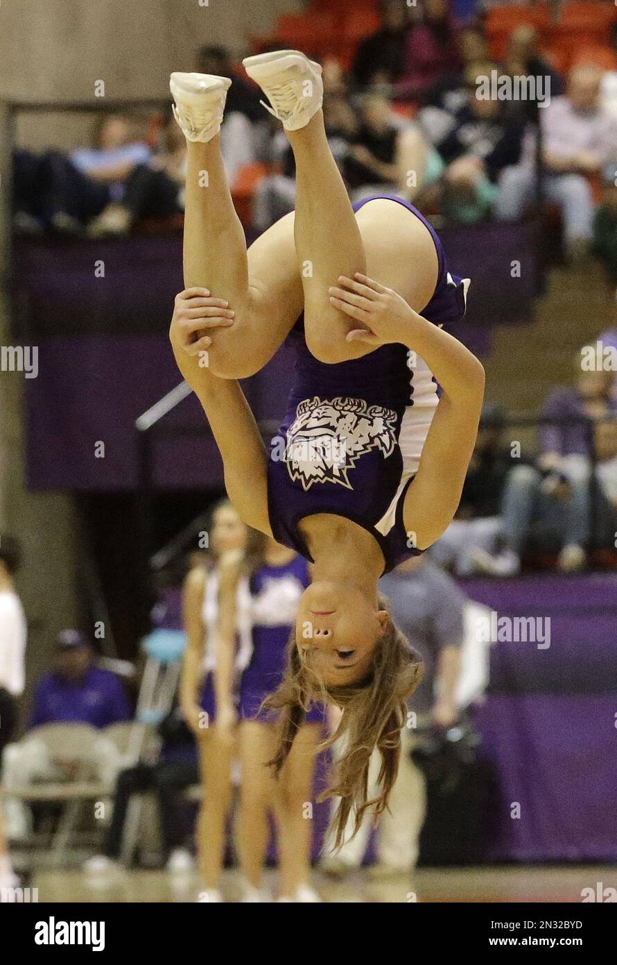 A TCU cheerleader flips during the second half of an NCAA college ...