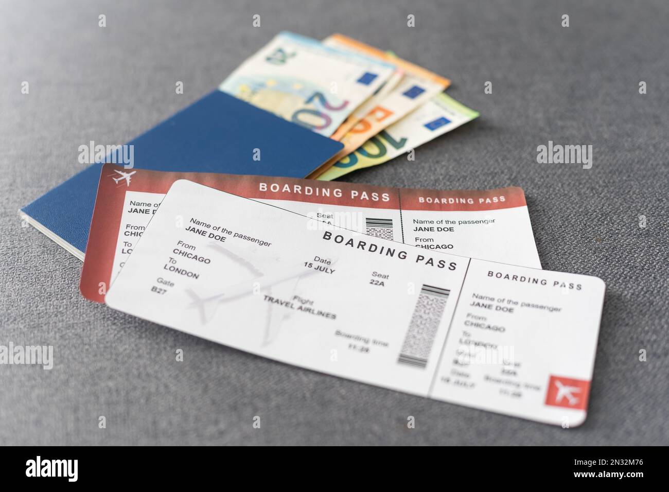 Two blue passports, green boarding pass, flight tickets gray background ...