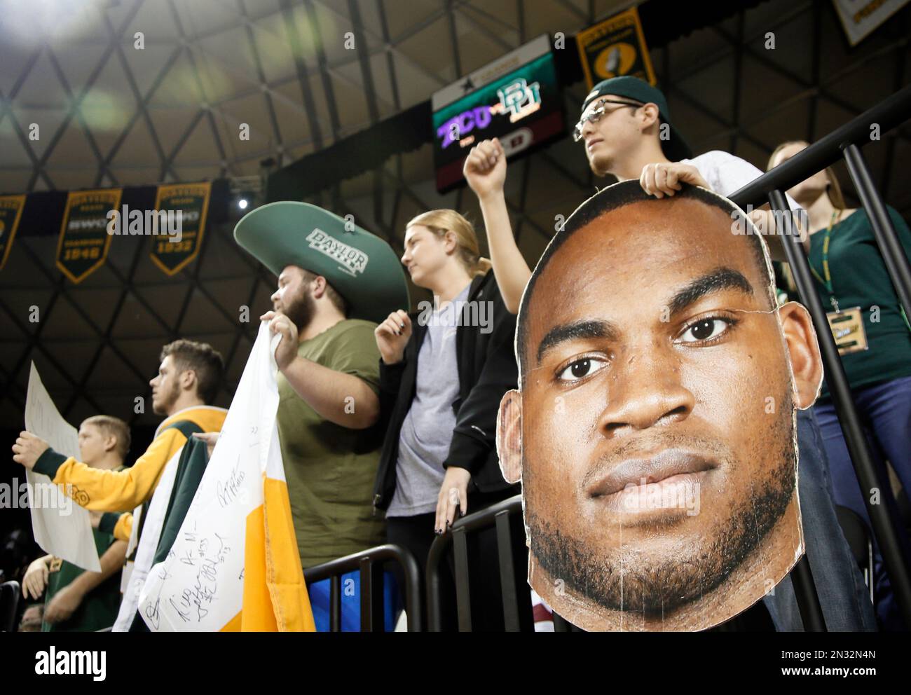 Baylor fans cheer on their team as one holds a cardboard cut out of ...