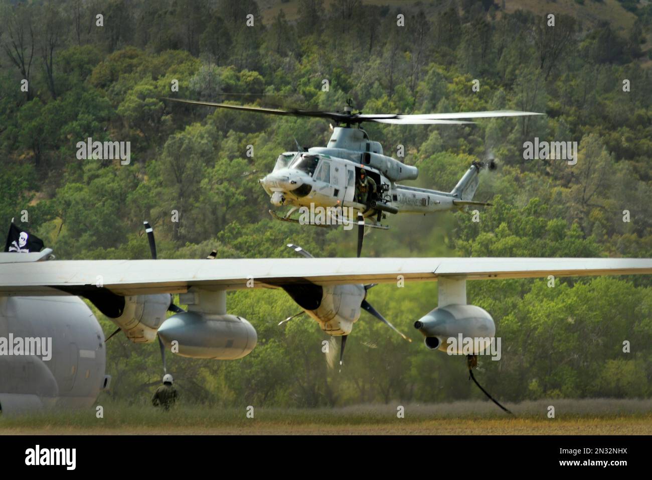 Helicopter in13th Marine Expeditionary Unit, takes off while C-130 ...