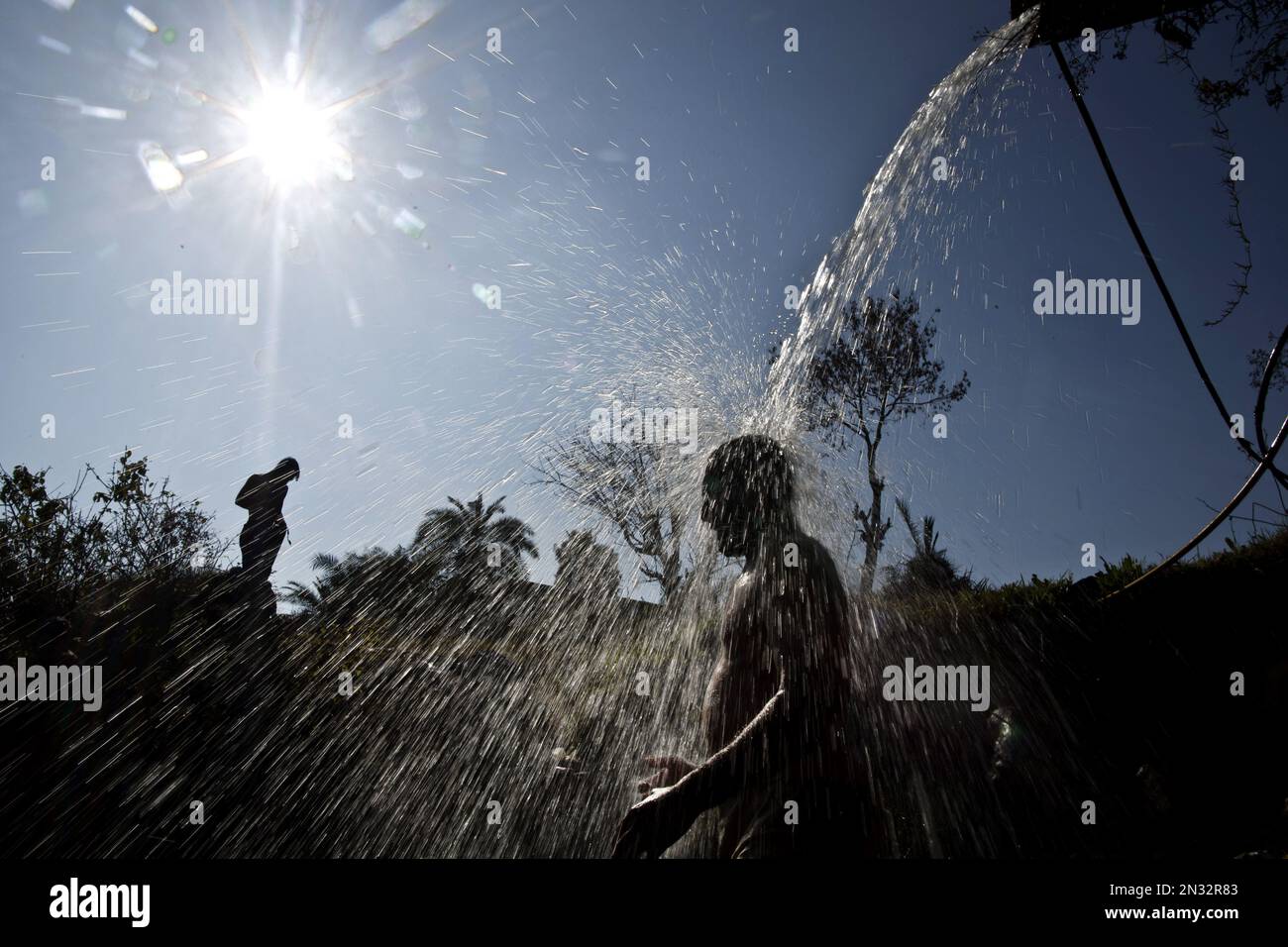 Pakistani labor Arshad Massi, 34, showers under a water supply pipe in ...