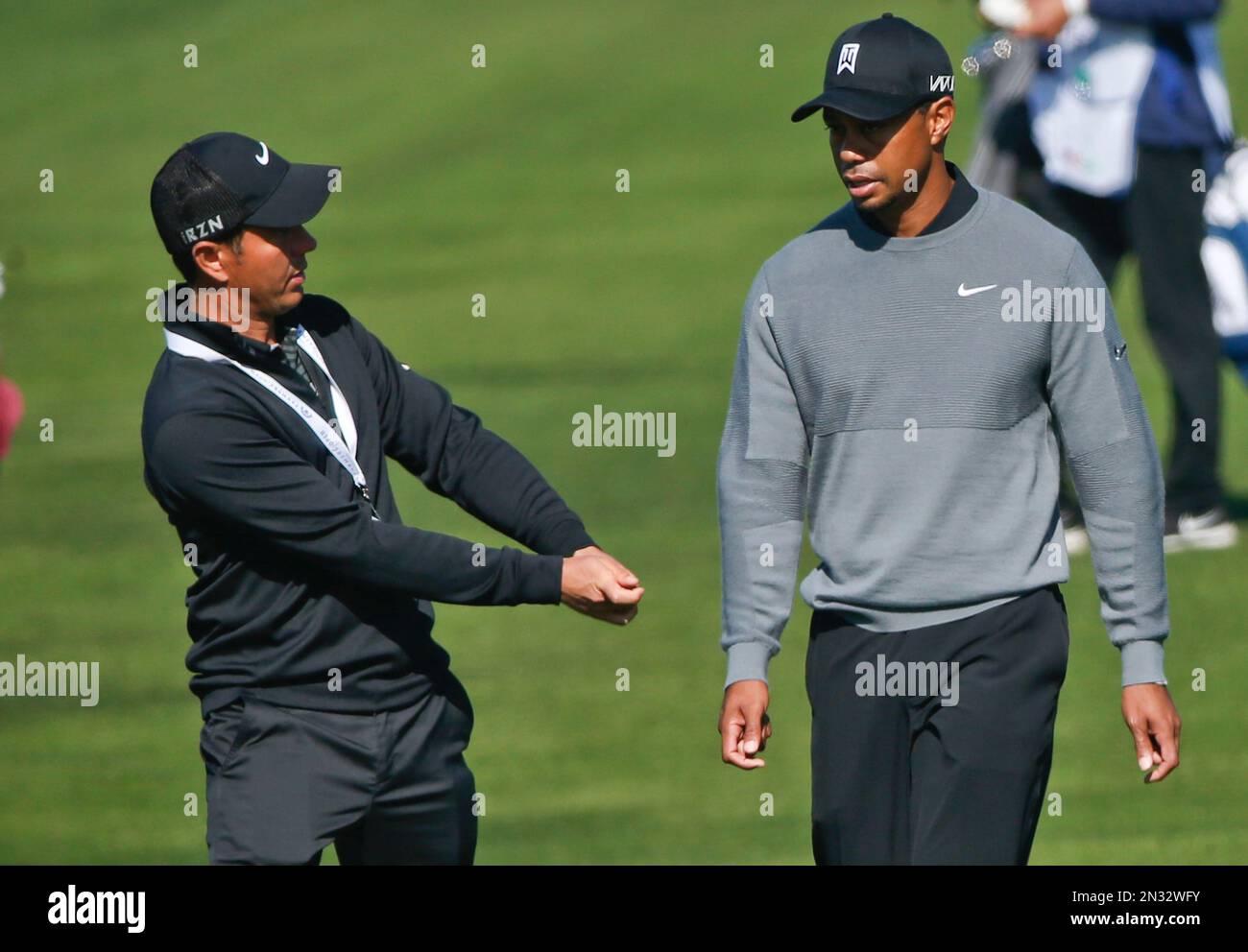 Teacher Chris Como demonstrates a swing position to Tiger Woods during ...