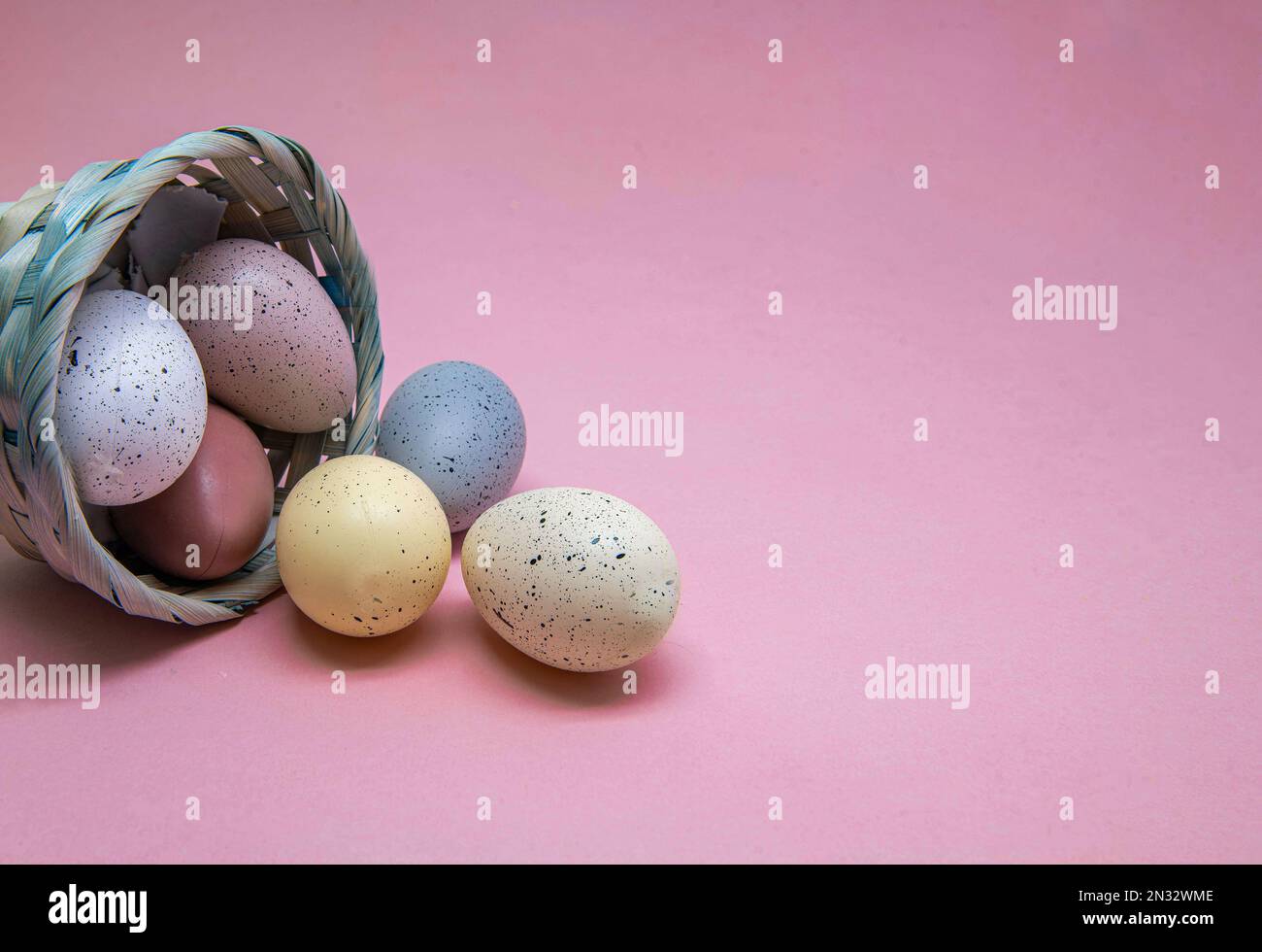 Easter eggs in a basket on its side isolated on a pink background Stock ...