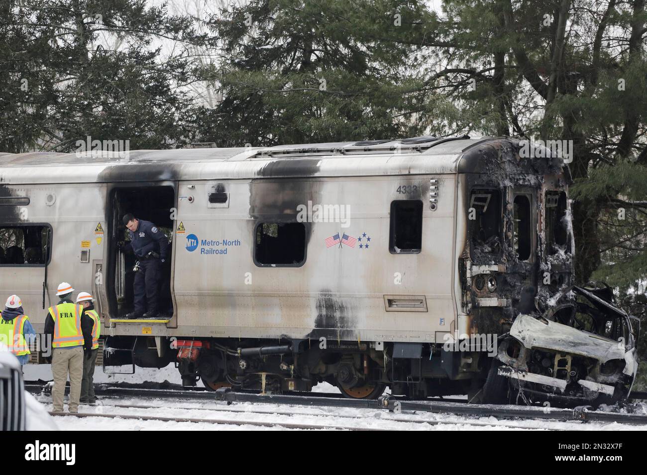 An official looks out the door of a Metro-North Railroad train, in ...