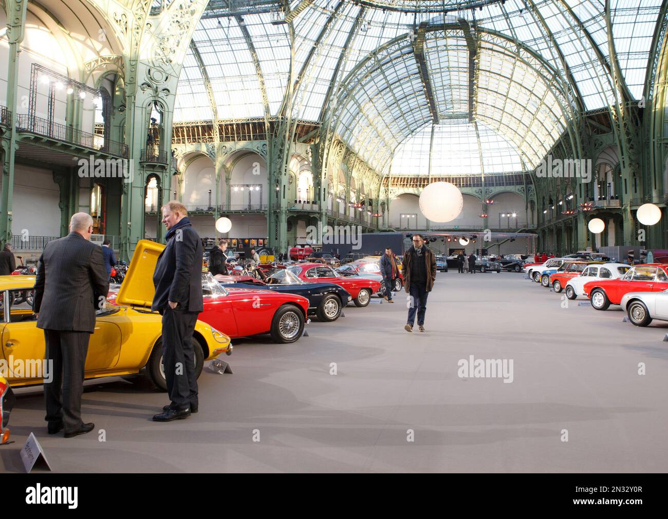 Visitors walk past vintage and classic cars displayed by Bonhams ...