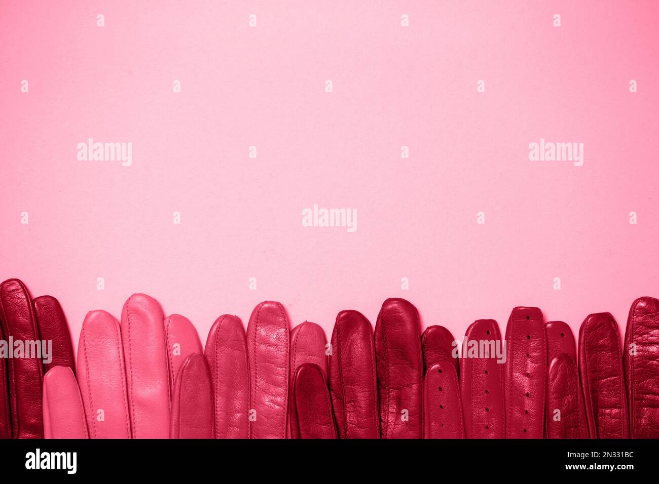Many bright multi-colored gloves on a pink background Stock Photo - Alamy