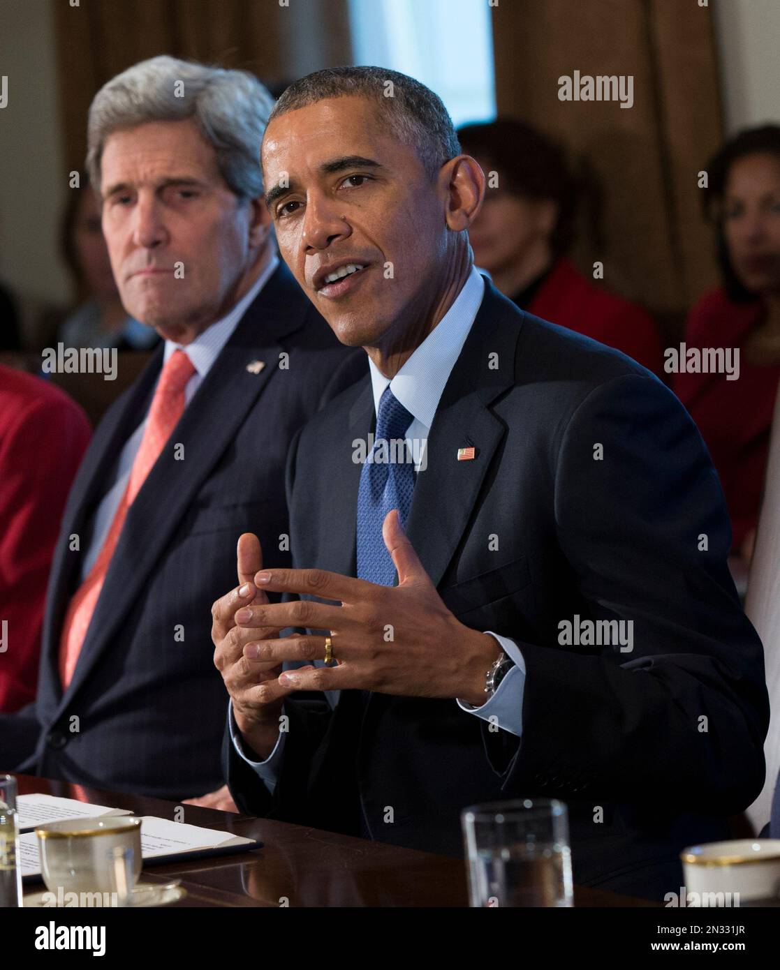 Secretary of State John Kerry, left, looks on as President Barack Obama ...