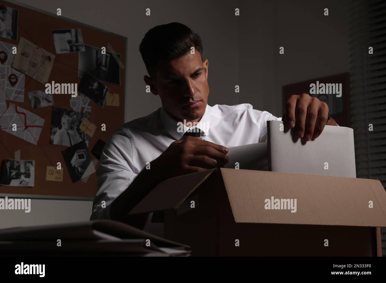 Professional detective doing paperwork in his office Stock Photo - Alamy