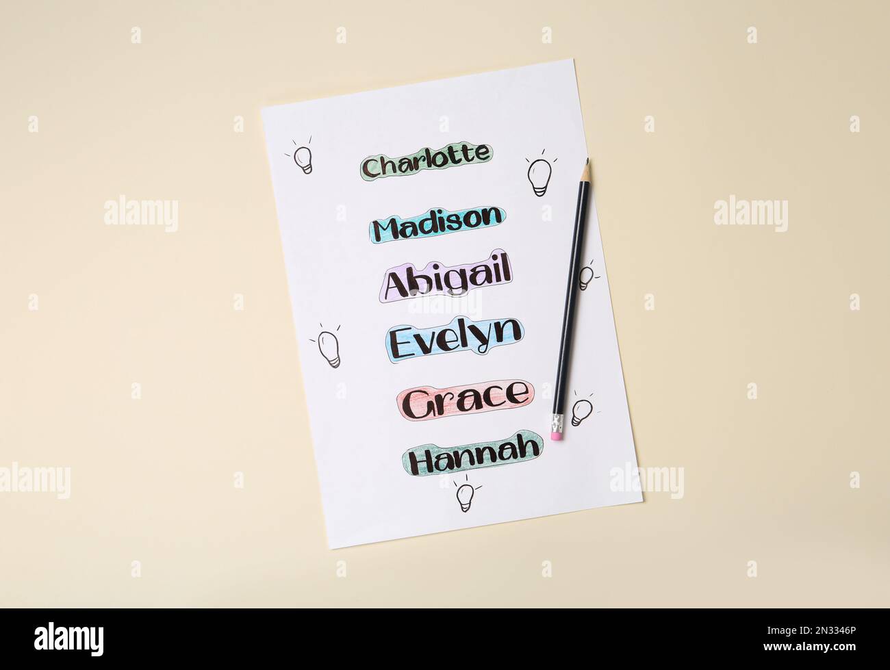 List of different baby names and pencil on beige background, top view ...