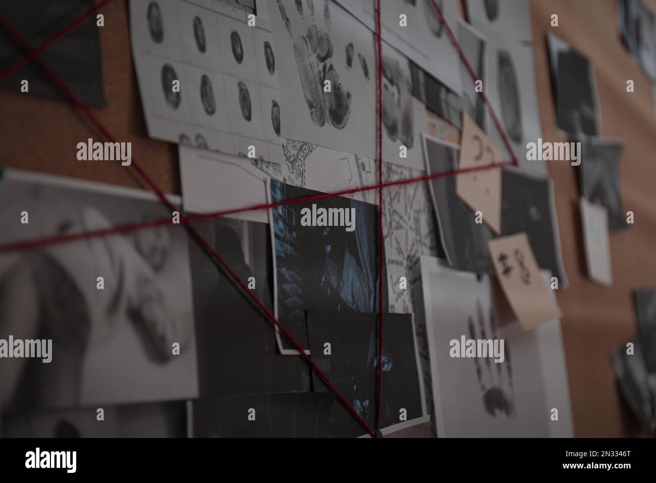 Detective board with crime scene photos, stickers, clues and red thread ...