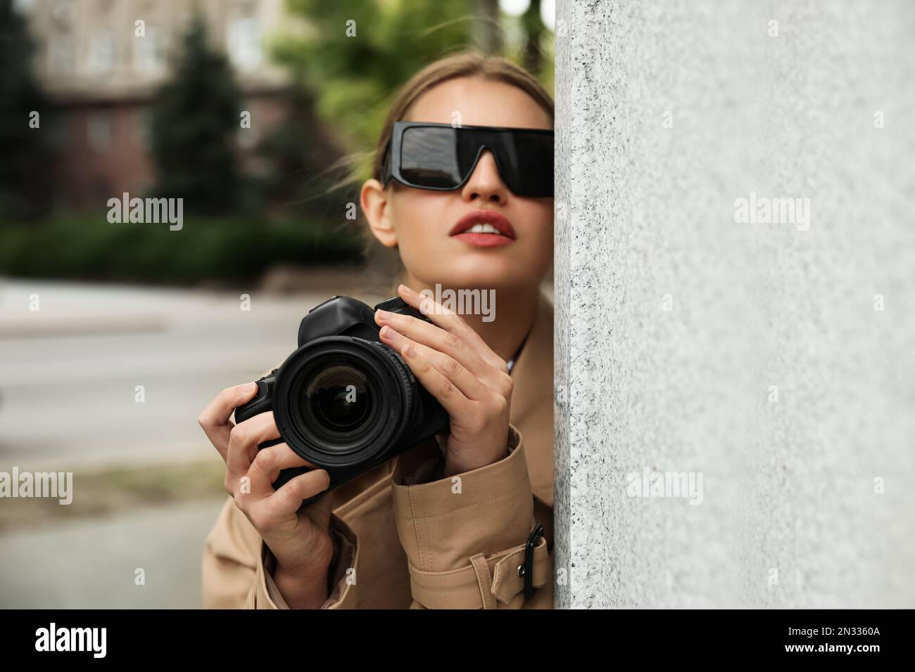 Private detective with modern camera spying on city street Stock Photo ...