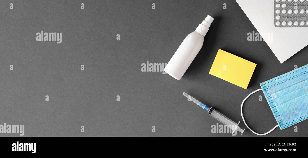 Gray modern doctor desk table with mask, notepad, syringe, sanitizer ...