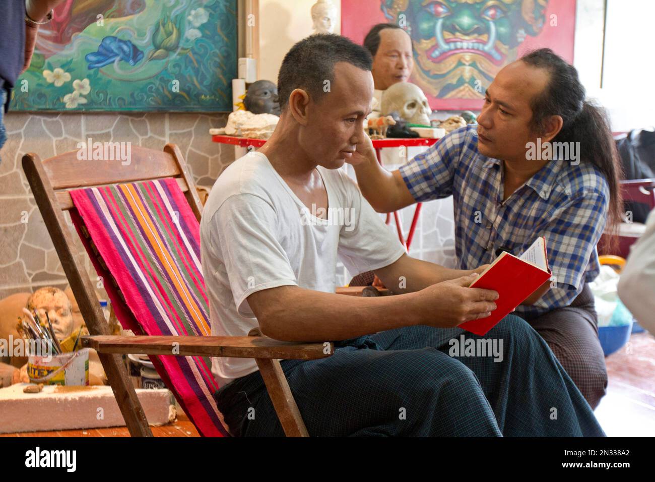 Artist Aung Kyaw Tun, right, gives a finishing touch to a life-size ...