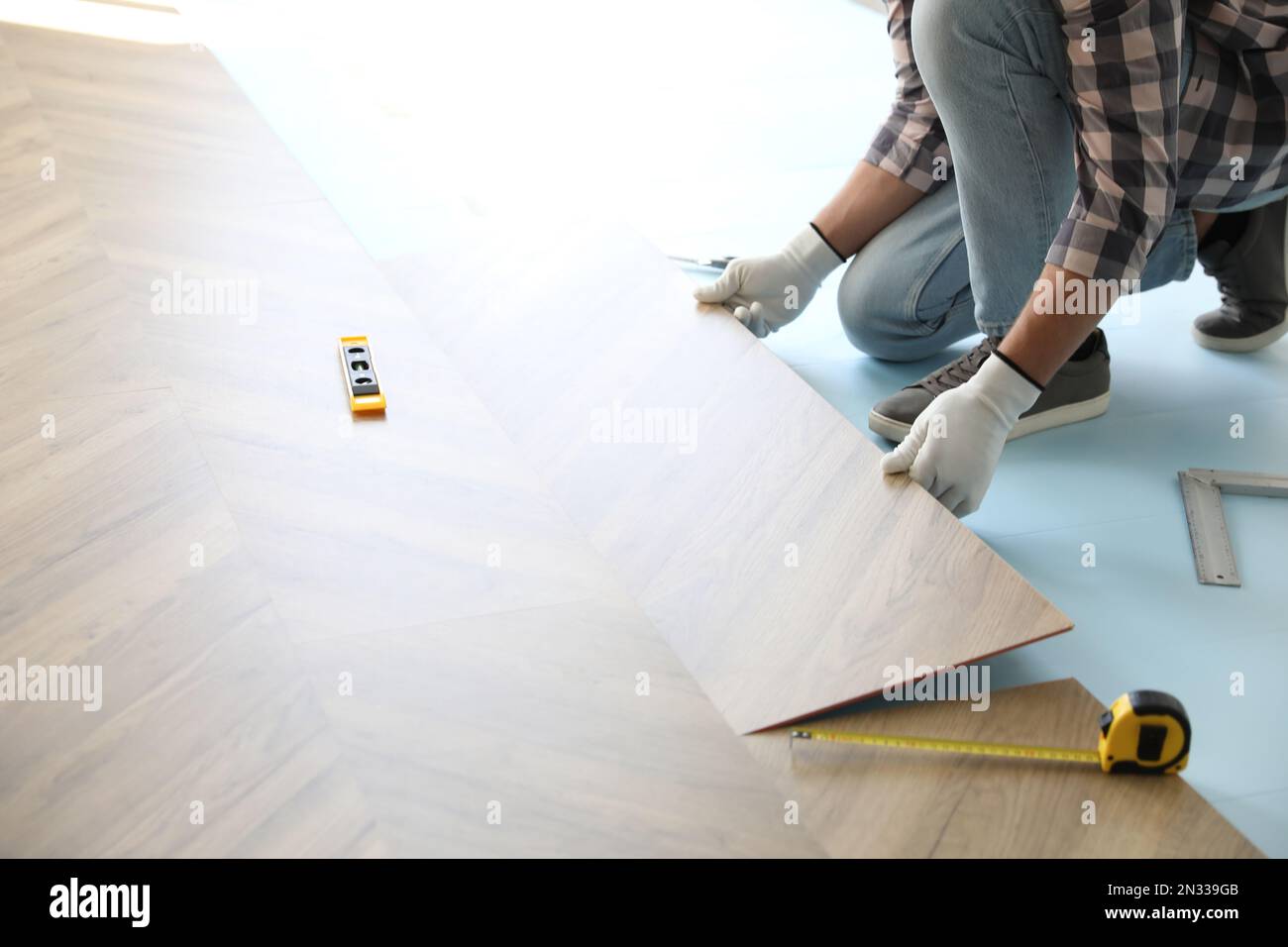 Worker installing laminated wooden floor indoors, closeup Stock Photo ...