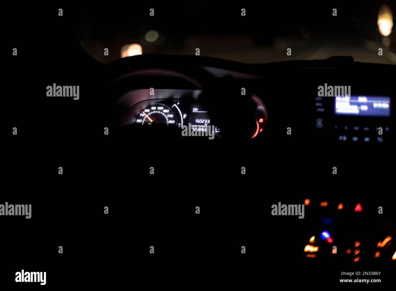 A modern car dashboard, illuminated for clear visibility during night ...