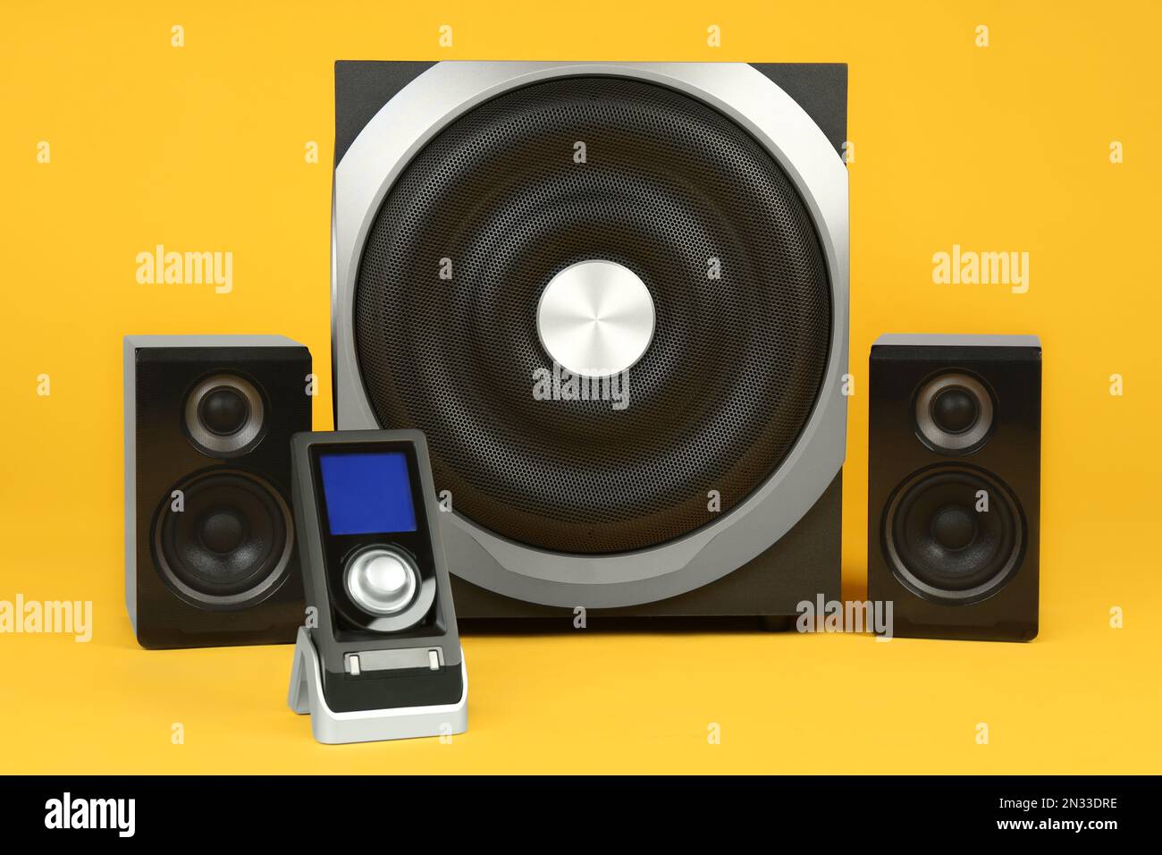 Modern powerful audio speaker system with remote on yellow background ...