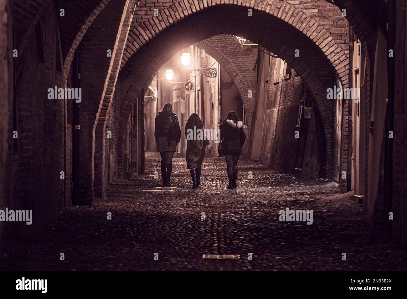 A photo of a group of friends, all girls, walking down a dark alley at ...
