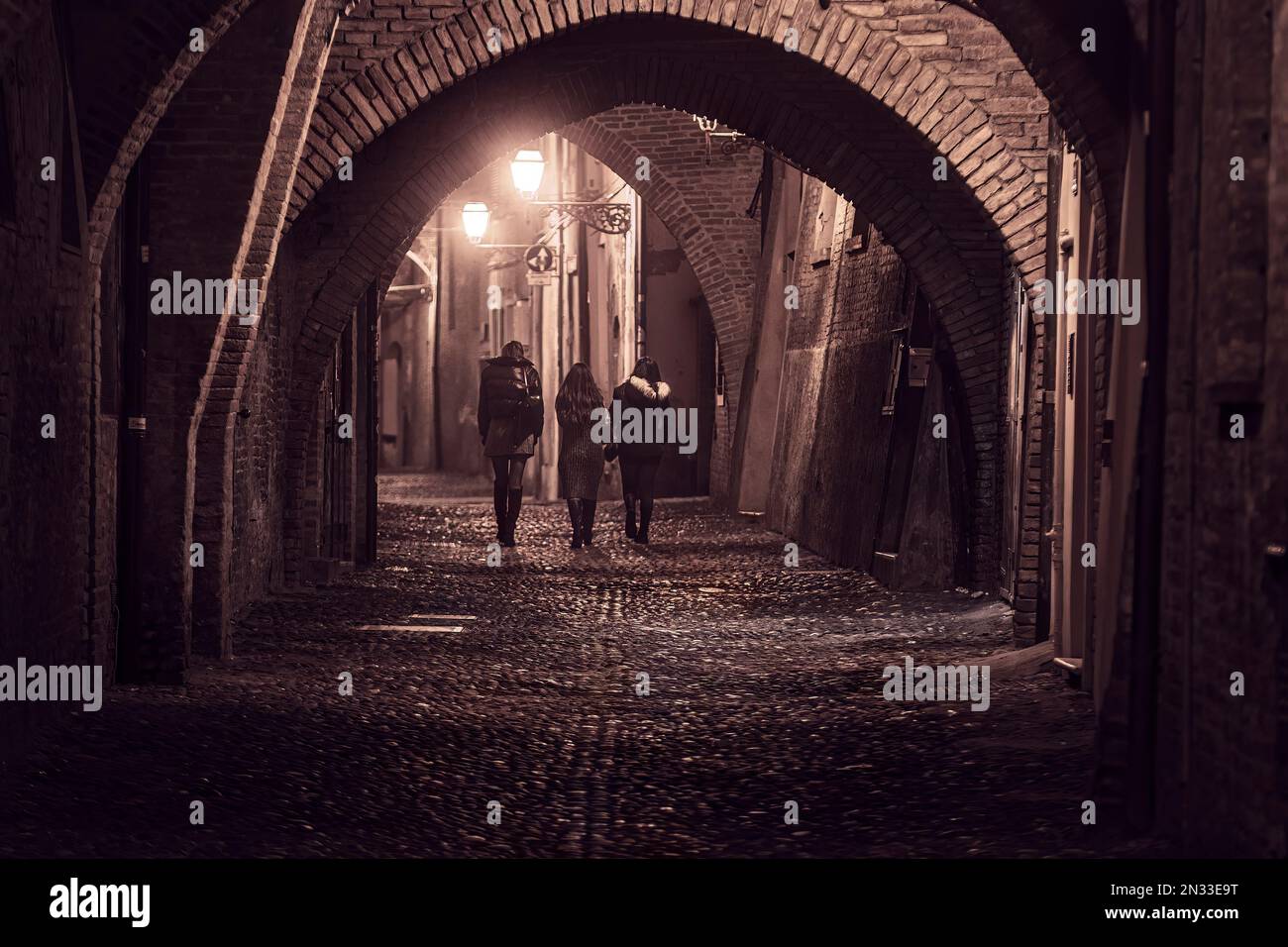 A photo of a group of friends, all girls, walking down a dark alley at ...