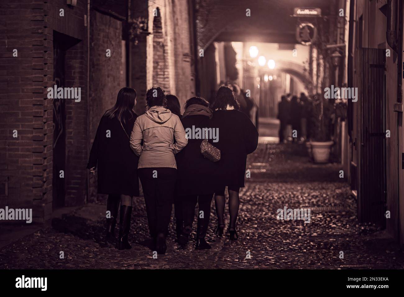 A photo of a group of friends, all girls, walking down a dark alley at ...