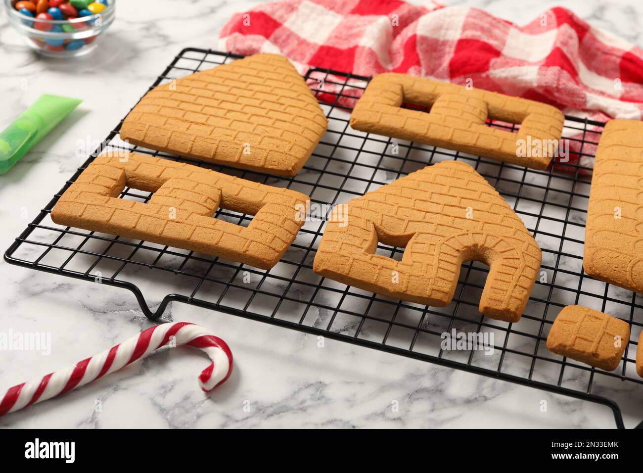 Parts of gingerbread house and candy cane on white marble table Stock ...