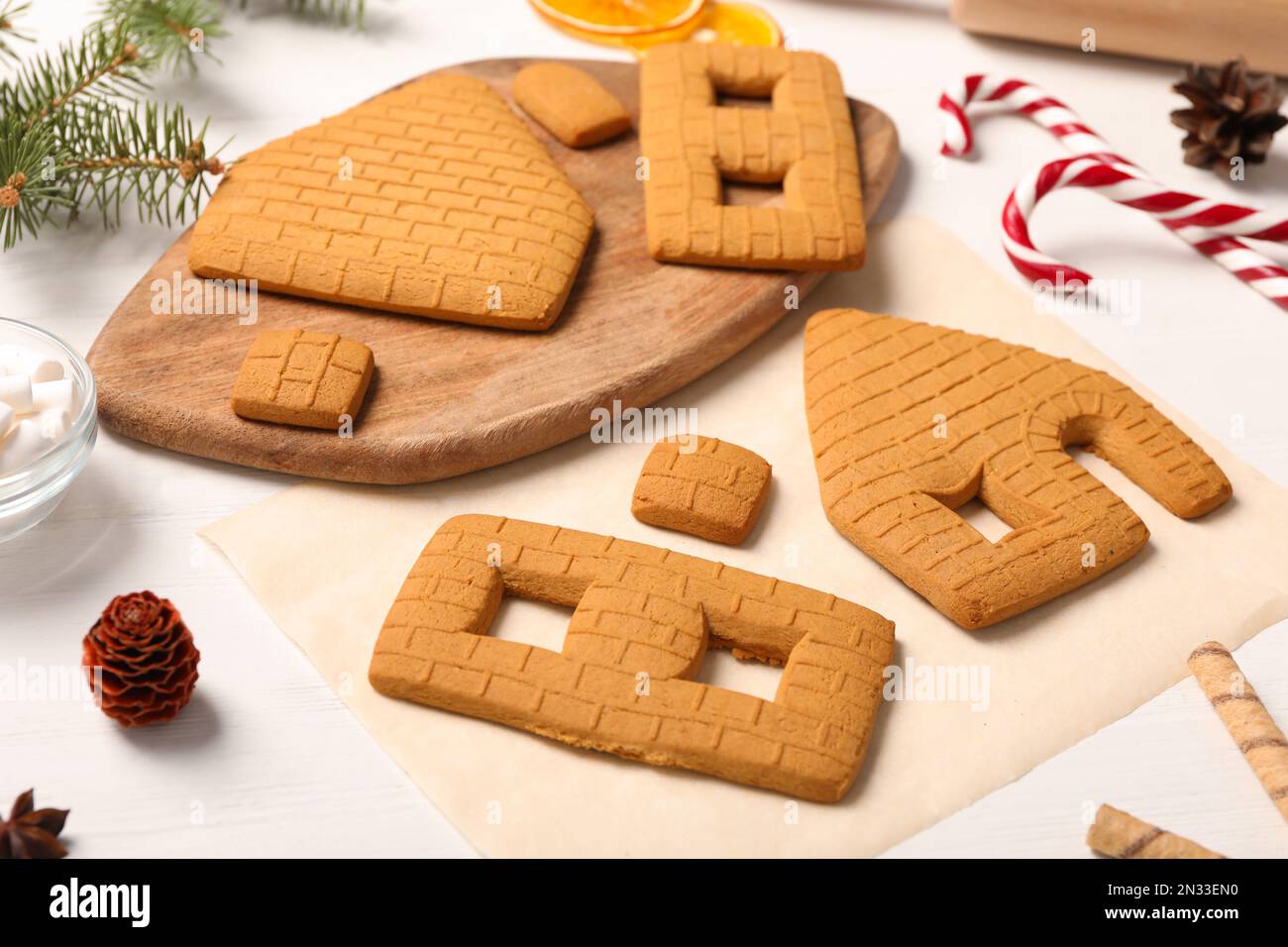 Parts of gingerbread house and ingredients on white table Stock Photo ...
