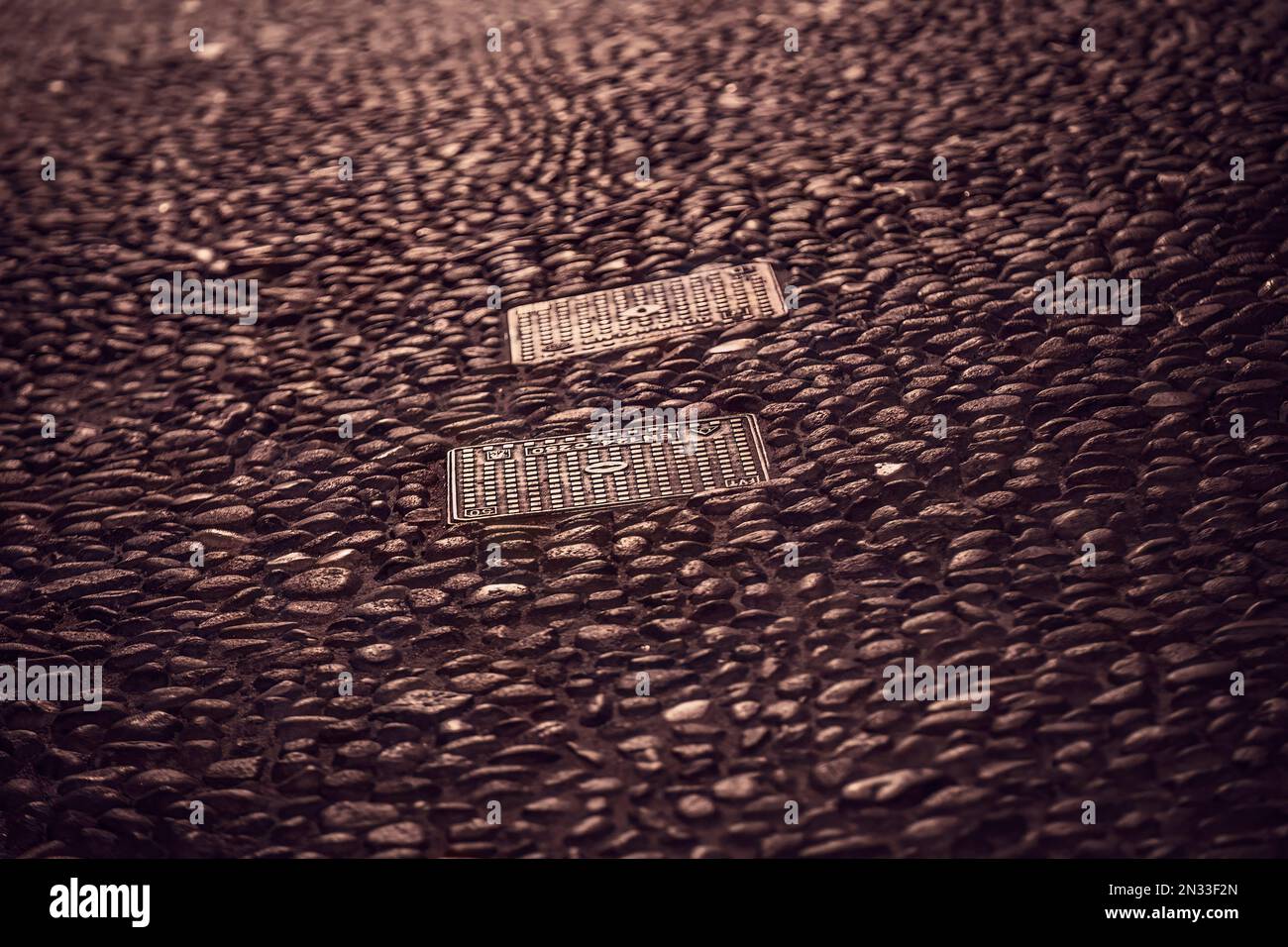 A photo of cobblestone streets and manhole covers in an eerie ...