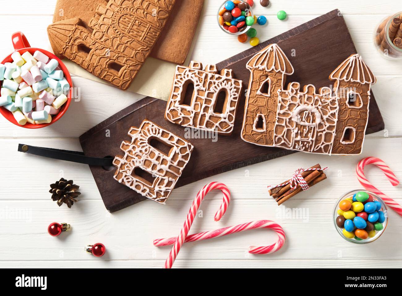 Flat lay composition with parts of gingerbread house on white wooden ...