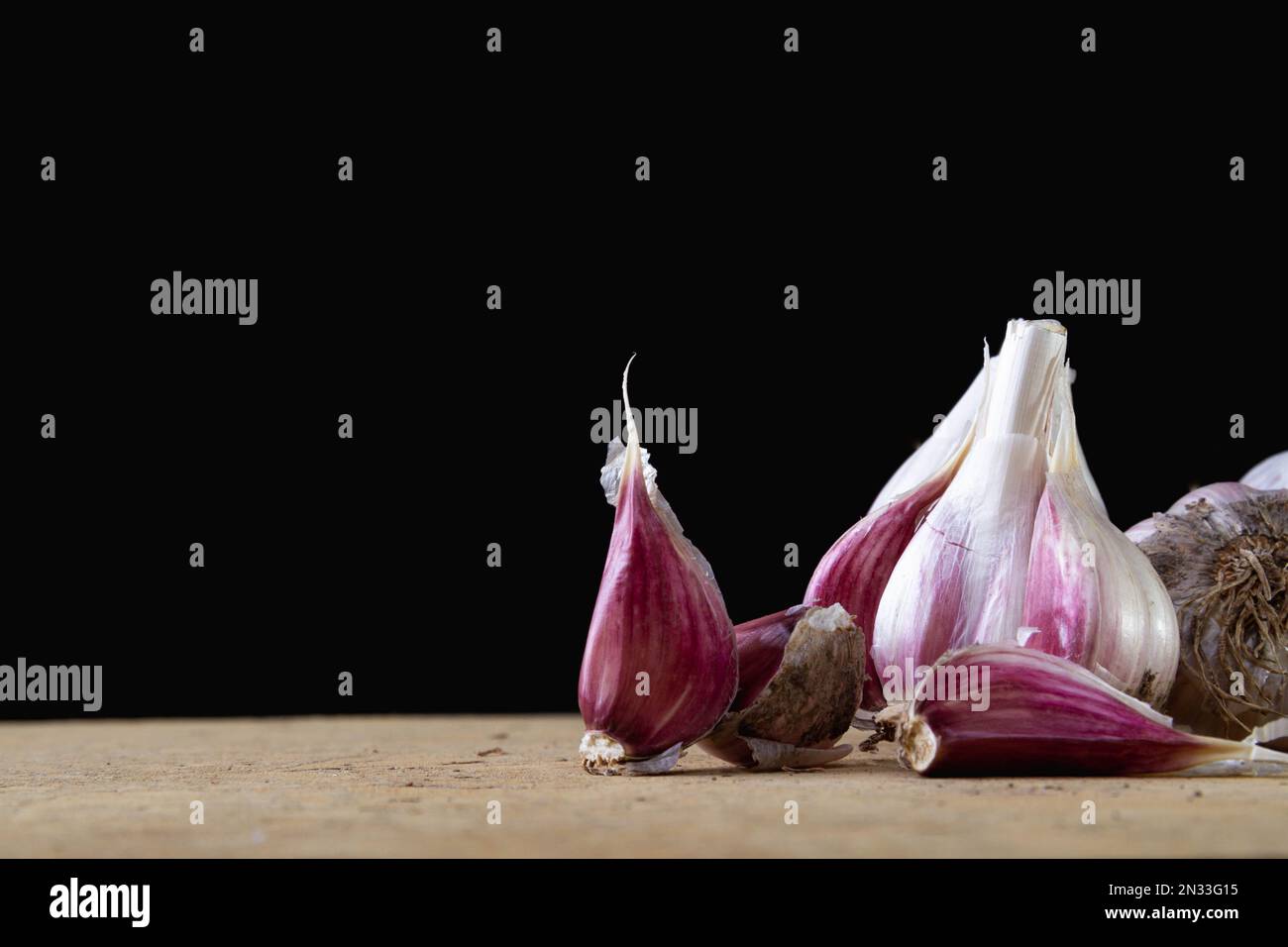 Garlic on black background. Fresh garlic on store counter. Healthy ...