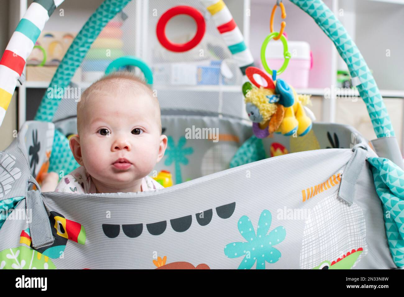 Cute caucasian baby girl on the play mat. Baby's first year Stock Photo ...