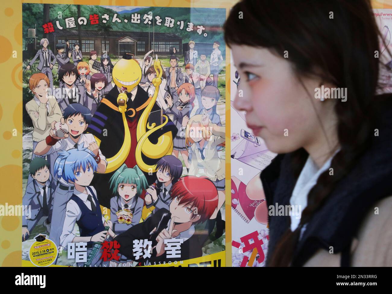 A woman walks past a poster of animation "Assassination Classroom" in ...