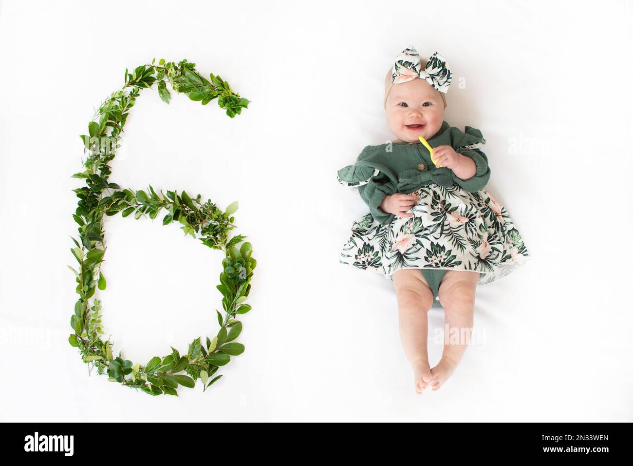 6 month old baby girl in a green dress. Baby milestone six months Stock ...