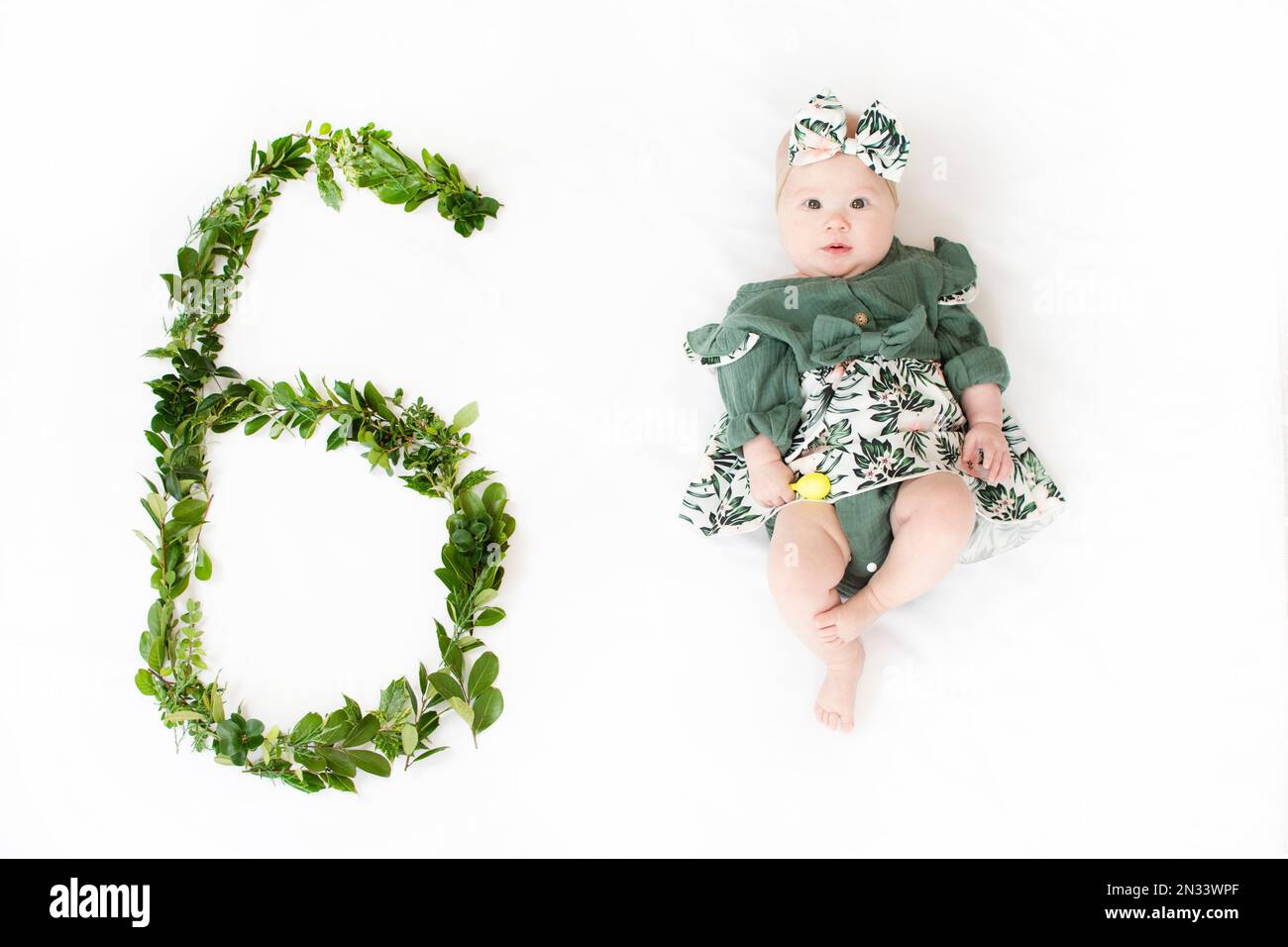 6 month old baby girl in a green dress. Baby milestone six months Stock ...