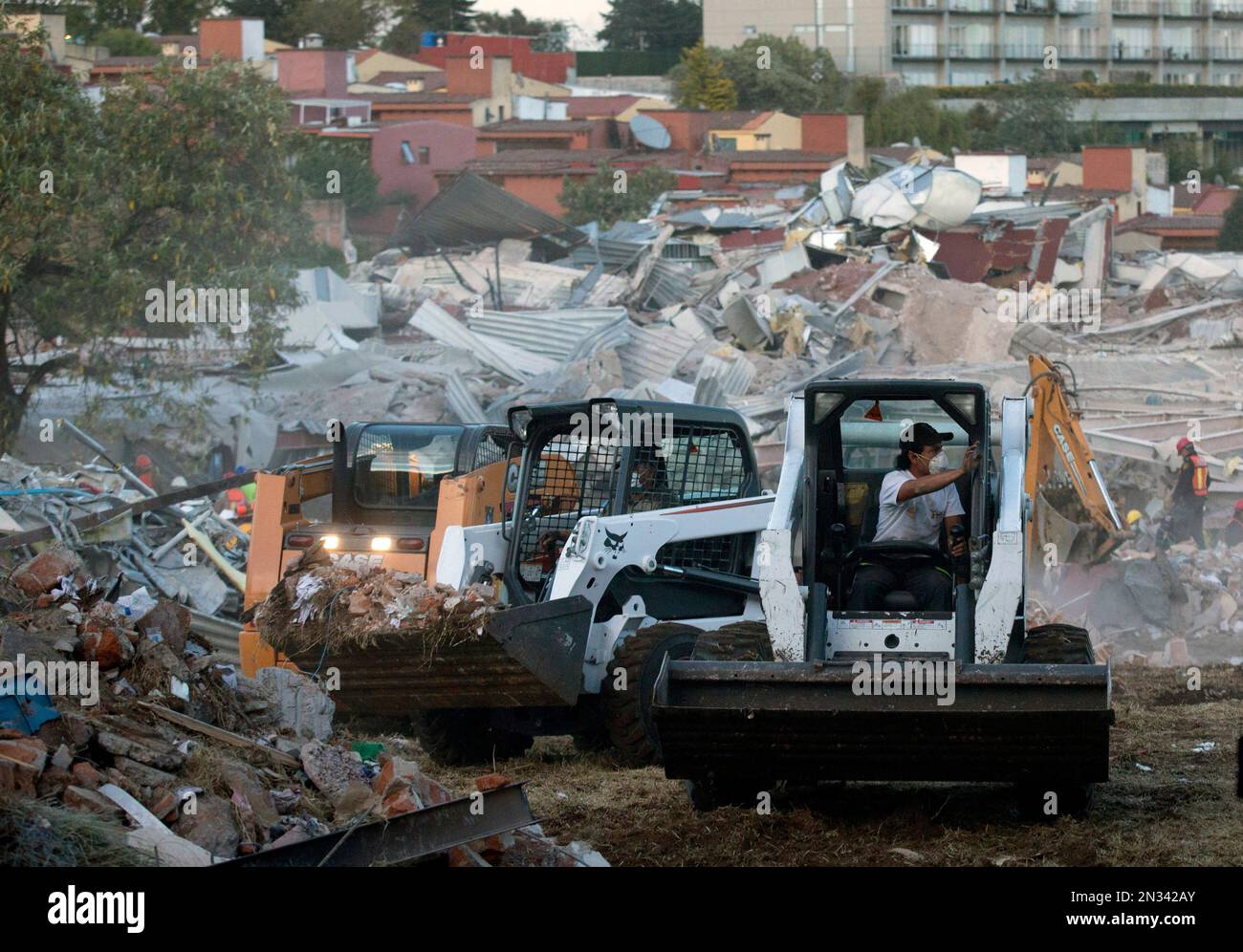 Rescue workers move rubble as the search for survivors continues amid ...