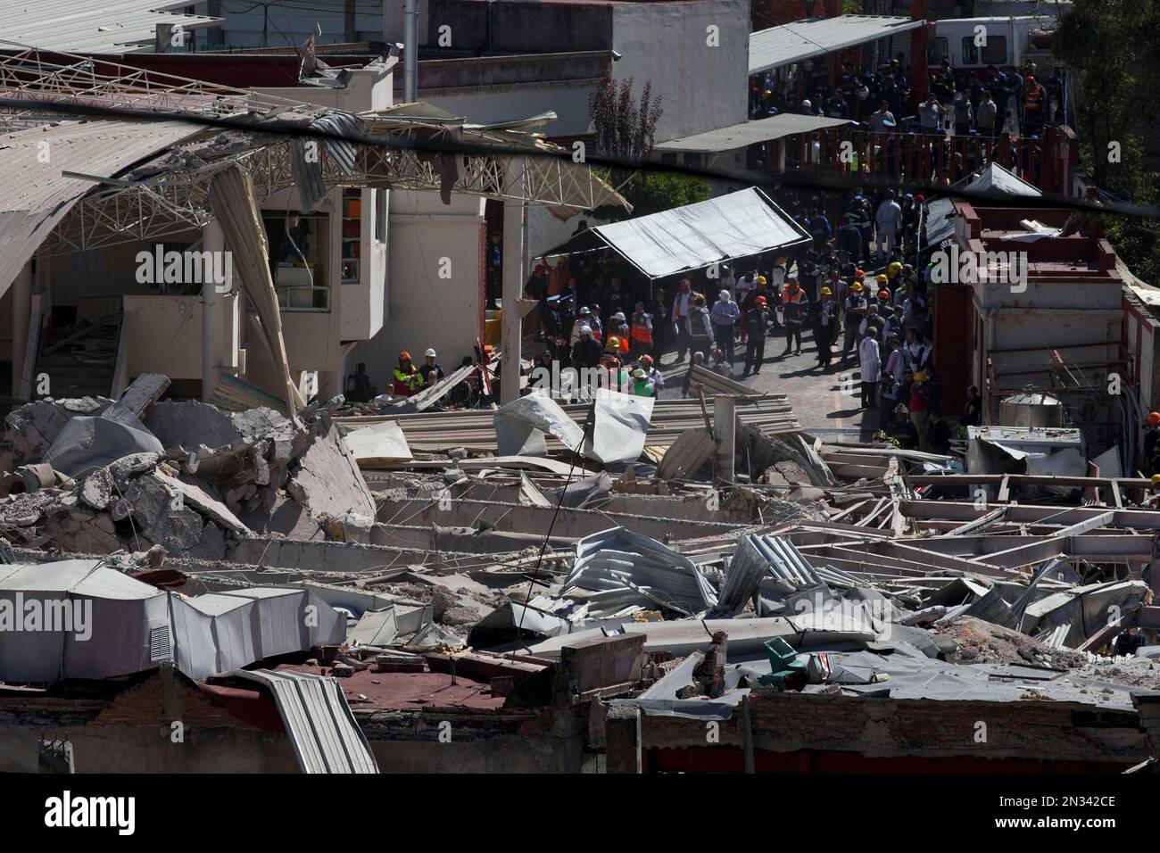 Rescue workers and police stand around the wreckage of a maternity and ...