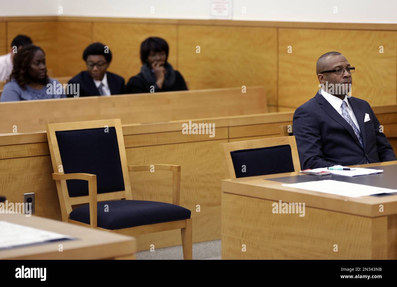 While his family looks on, Michael Waithe sits in a courtroom while ...