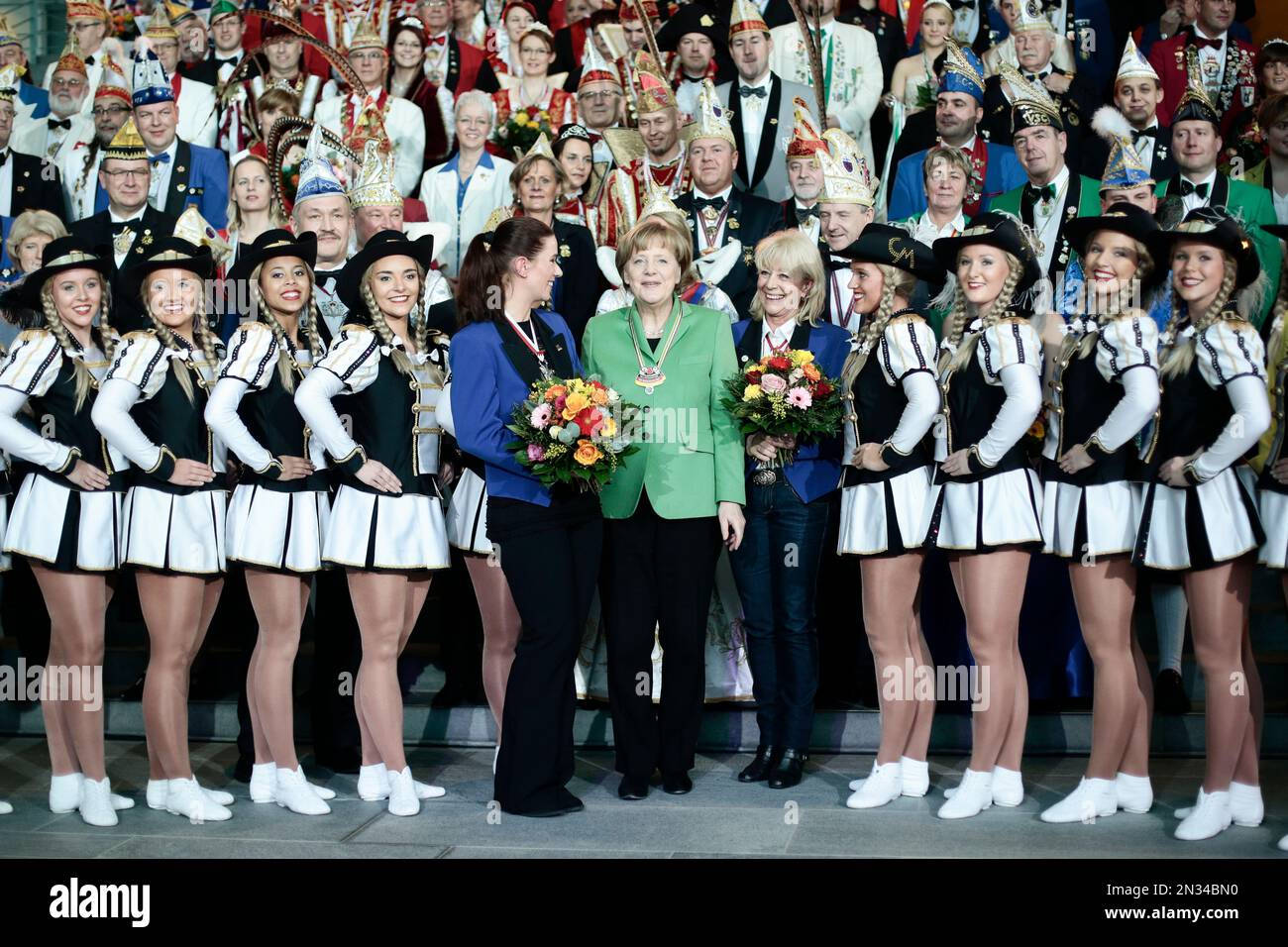 German Chancellor Angela Merkel poses with carnival dancers during a ...