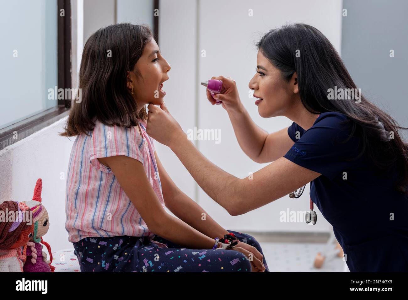 Paediatrician checking a child's mouth in her medical office Stock ...