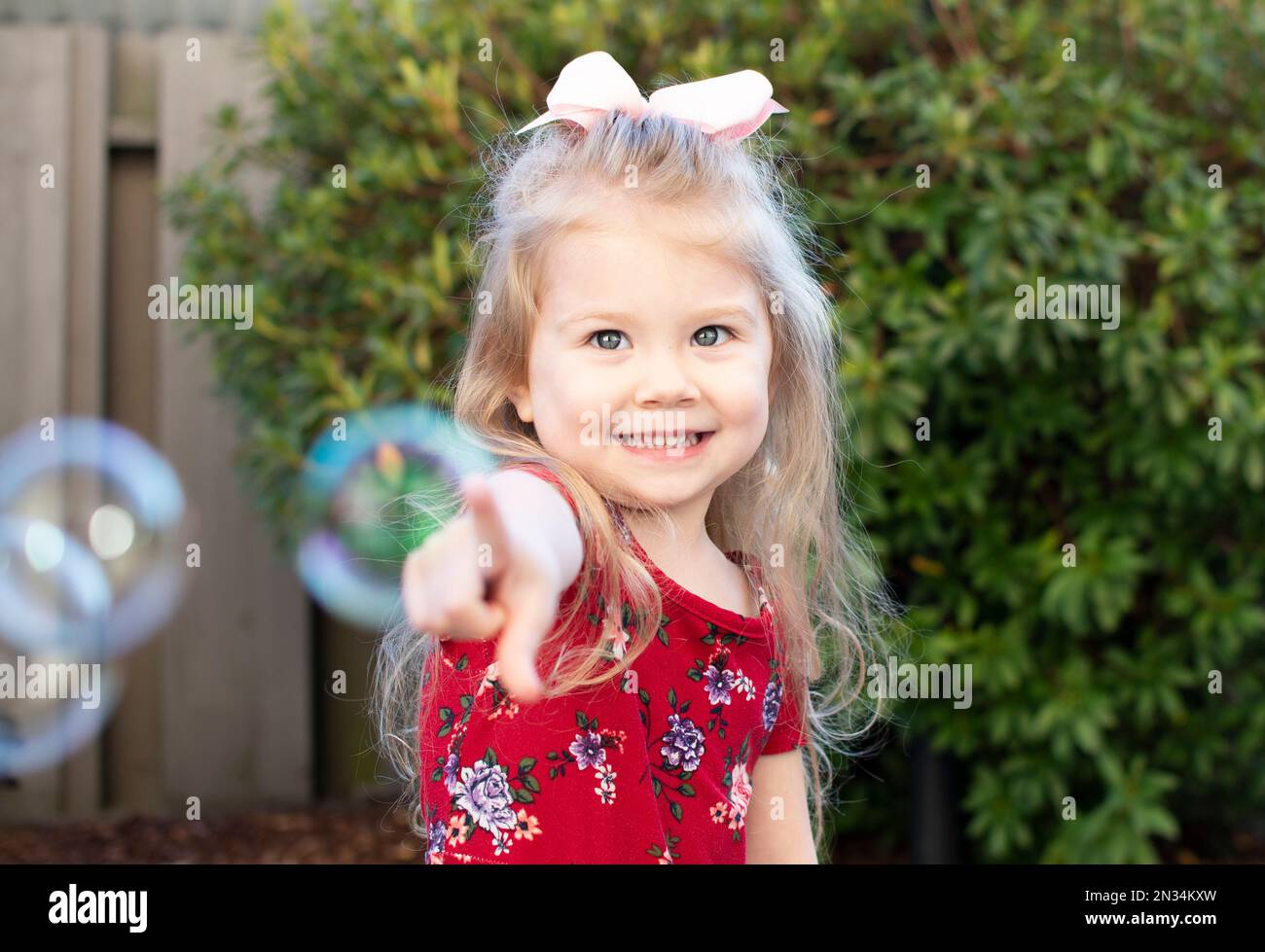 Little girl playing with bubbles. Happy child popping bubbles Stock ...