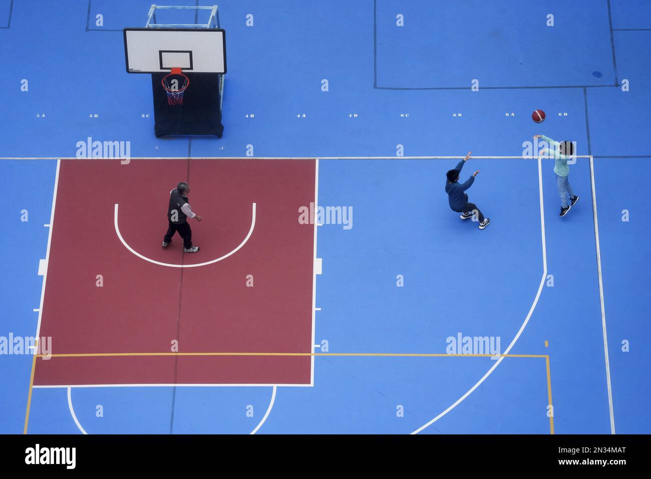 People play basketball at a ball court of a secondary school in Kwun ...