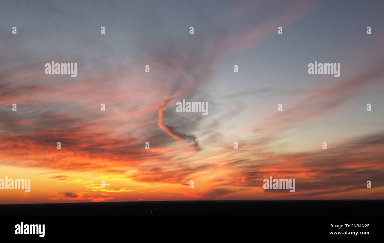 A view of the orange-shaded sunset sky with cirrus clouds Stock Photo ...