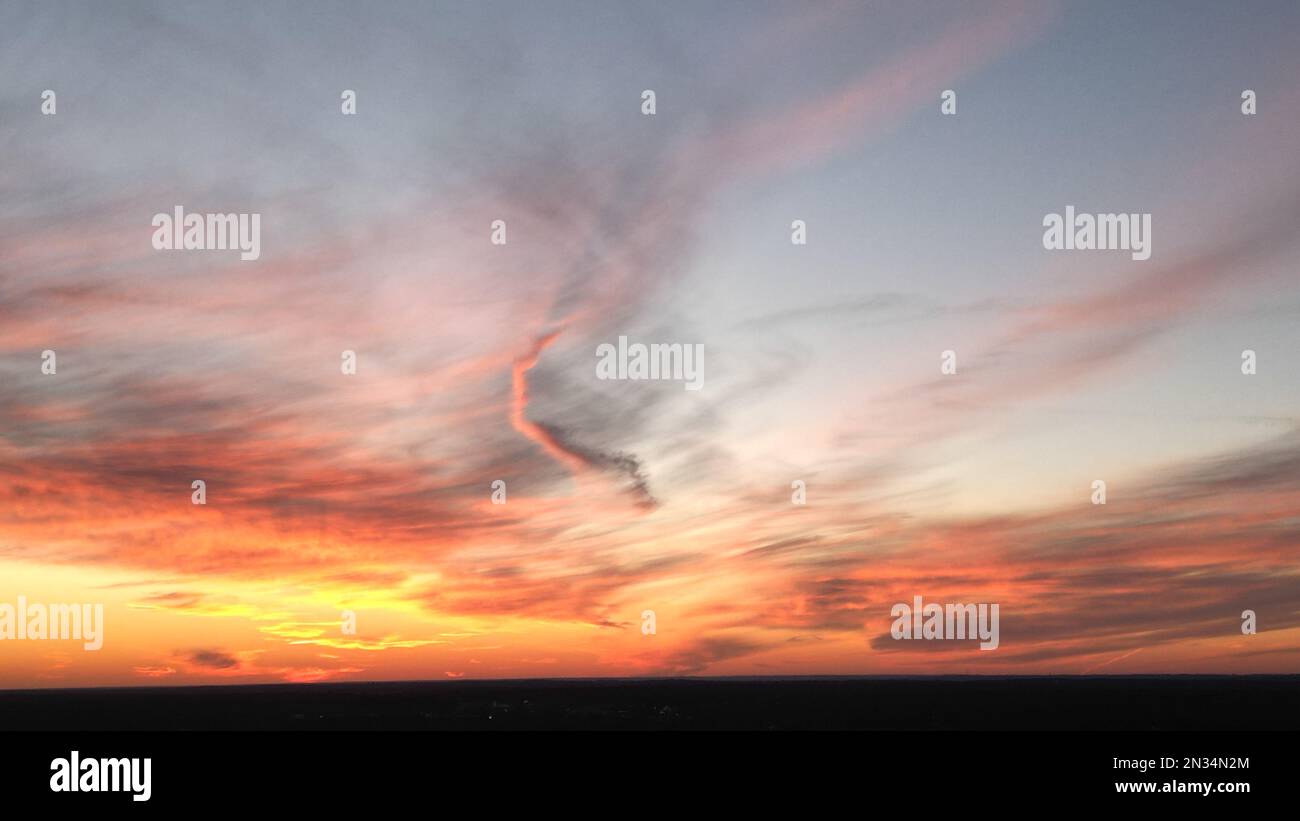 A view of the orange-shaded sunset sky with cirrus clouds Stock Photo ...